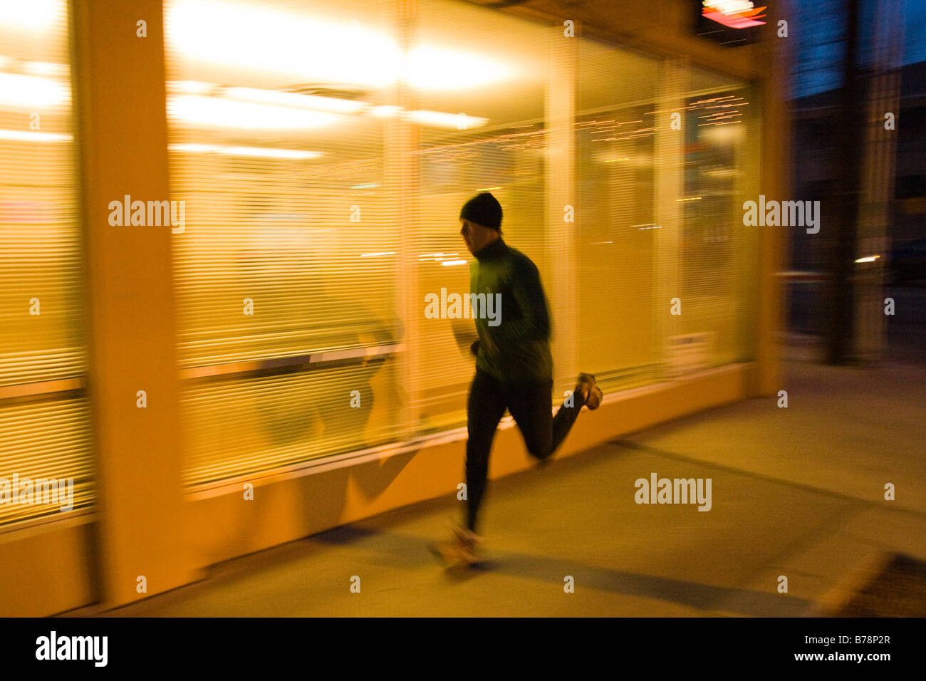 A man running along the road at night under the lights of Reno in ...