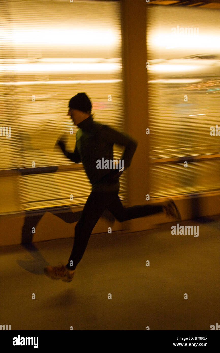 A man running along the road at night under the lights of Reno in ...