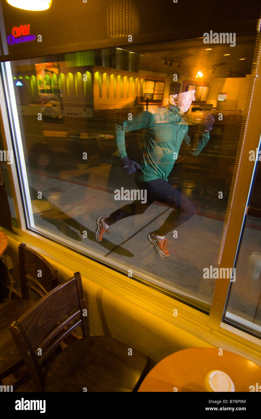 A man running along the road at night under the lights of Reno in ...