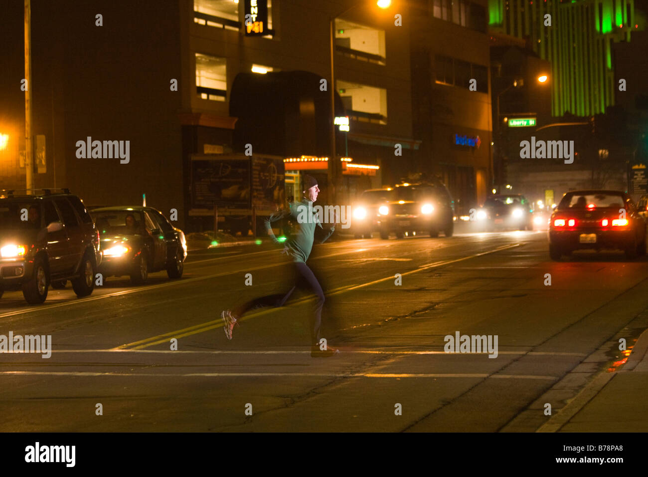 A man running along the road at night under the lights of Reno in ...