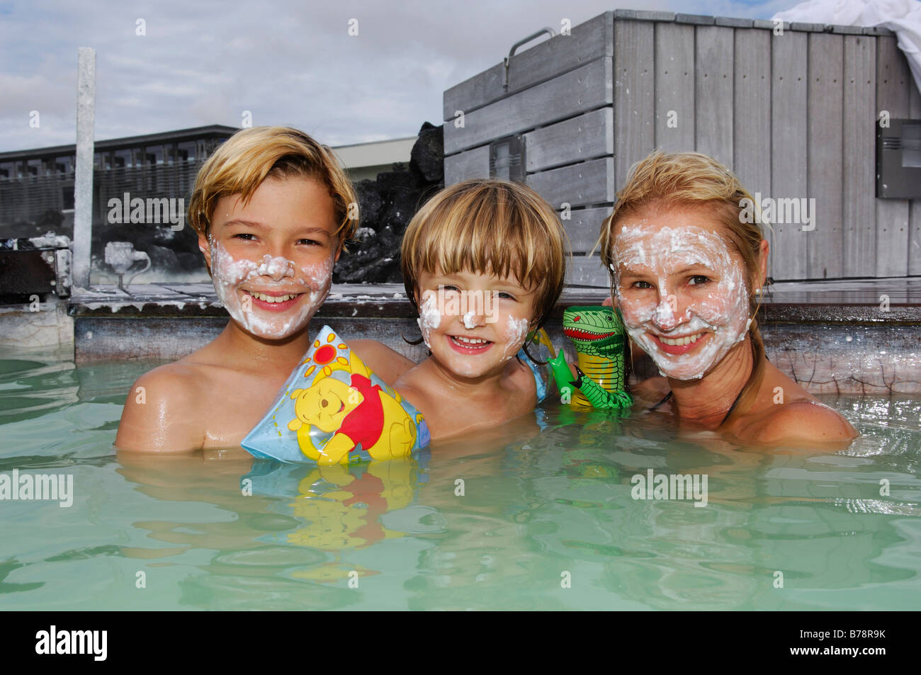 Woman with two children in geothermal spring, clay minerals, Blue ...