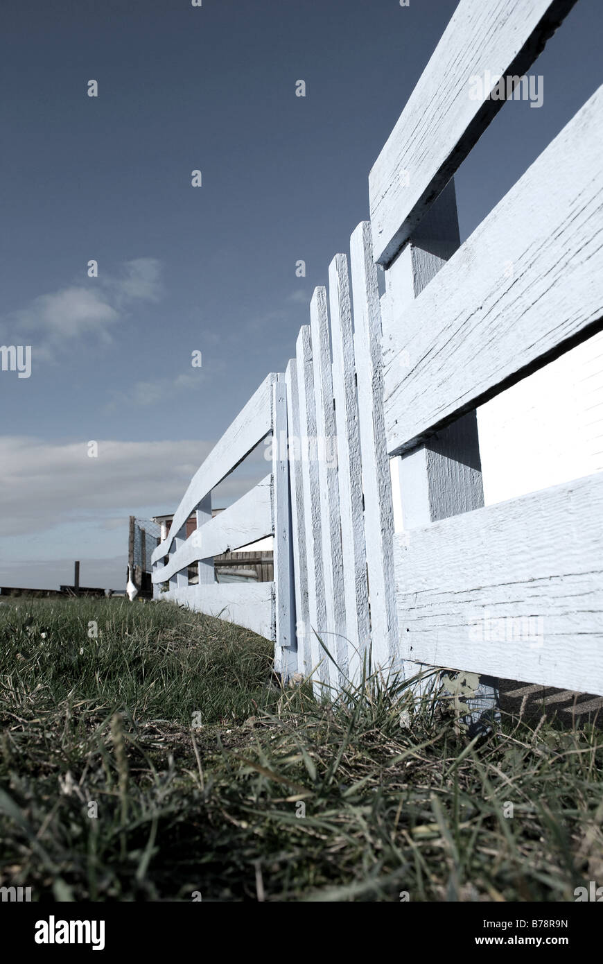 Desaturated blue fence disappearing into the distance Stock Photo - Alamy
