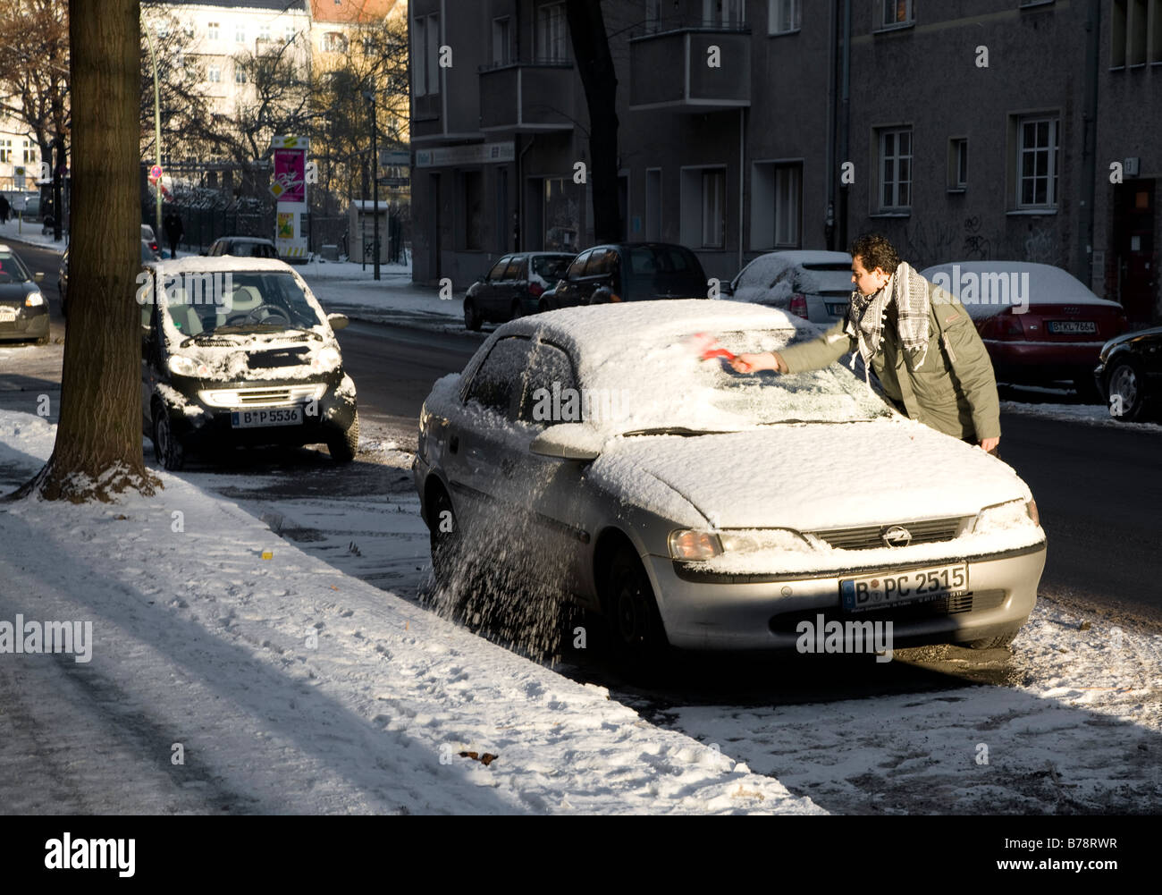 man scraping frost from a windscreen Stock Photo - Alamy