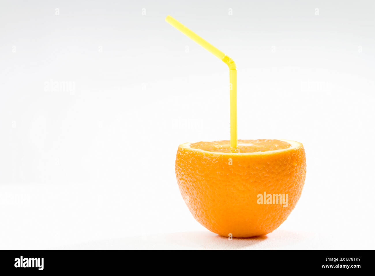An Orange With a yellow Straw, close-up Stock Photo - Alamy