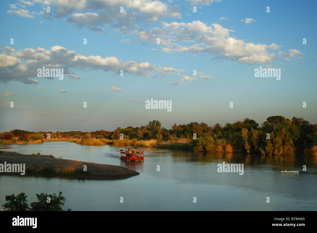 A scenic view of a boat on a sundowner cruise on the Orange river near ...