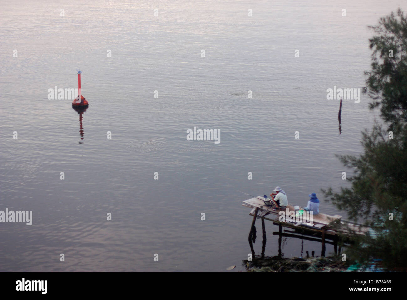 Local residents fish on a small dock in Anping Harbor. Tainan, Taiwan ...