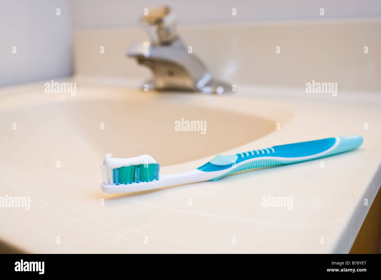 A tooth brush with tooth paste on bathroom sink Stock Photo - Alamy