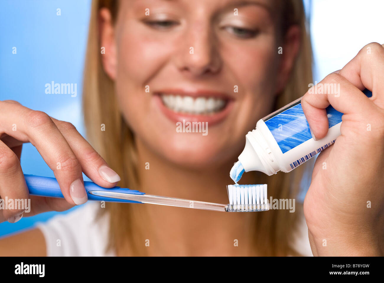 Young woman putting toothpaste on brush, portrait Stock Photo - Alamy