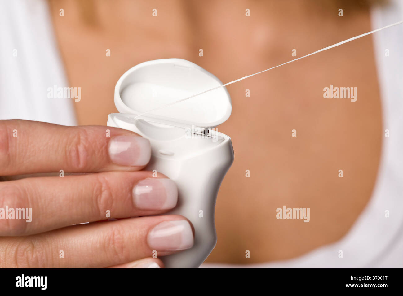 Person's hand pulling out dental floss, close-up Stock Photo - Alamy