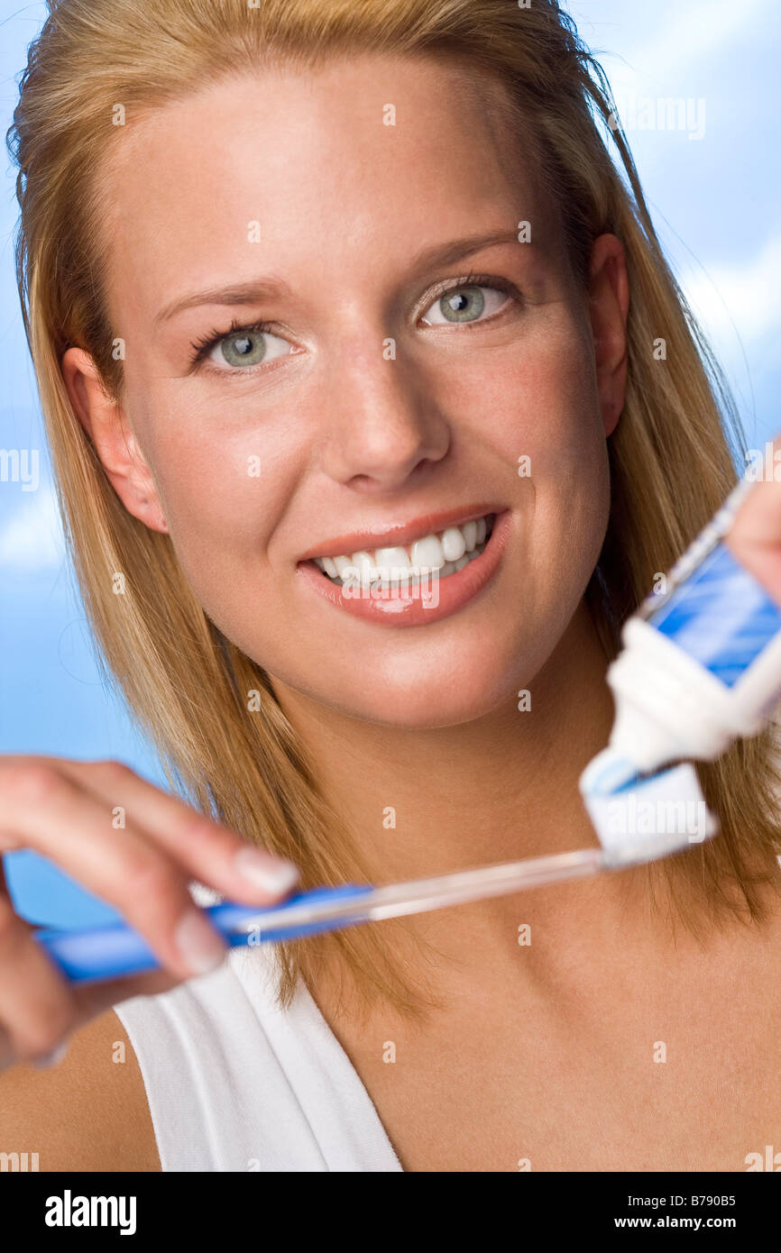Woman putting toothpaste on toothbrush hi-res stock photography and ...