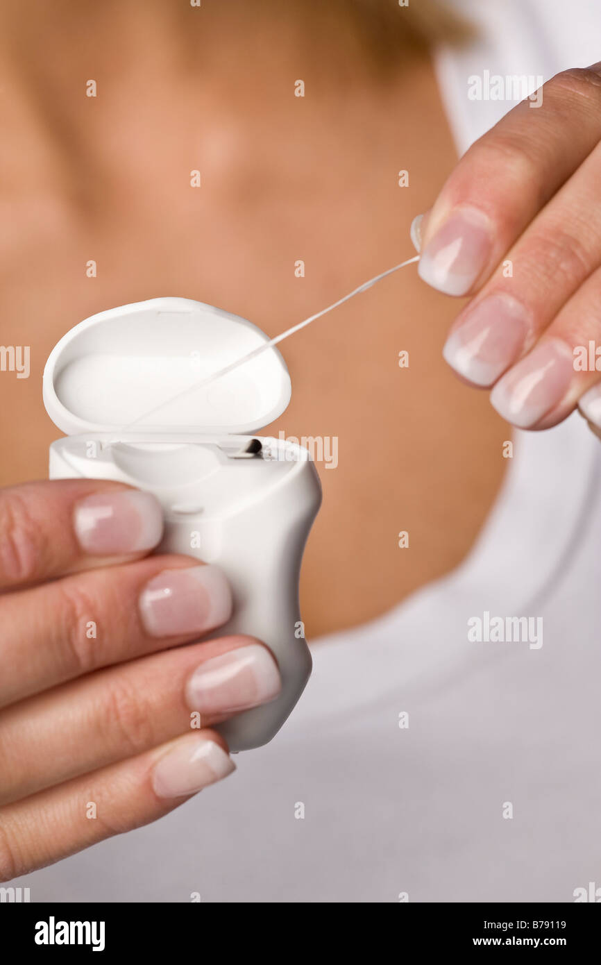 Person's hand pulling out dental floss, close-up Stock Photo - Alamy