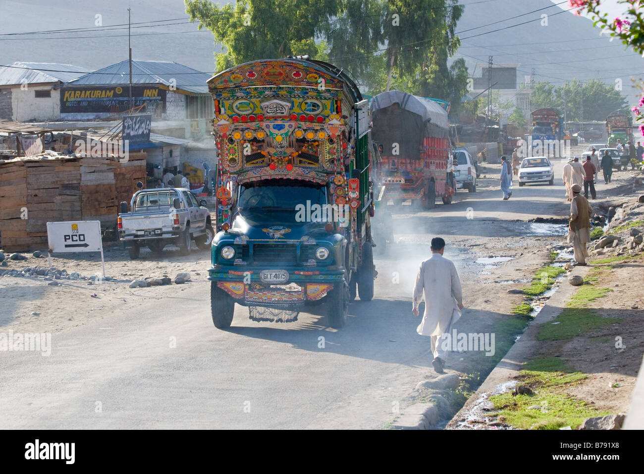 Ornate Pakistani trucks cars and pedestrians on the main street of a ...