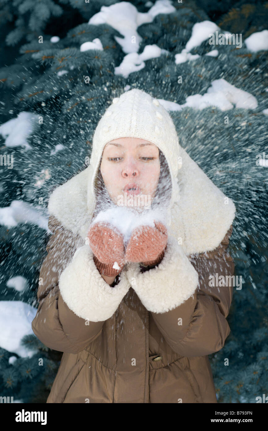 Young woman blowing snow from her hands Stock Photo - Alamy