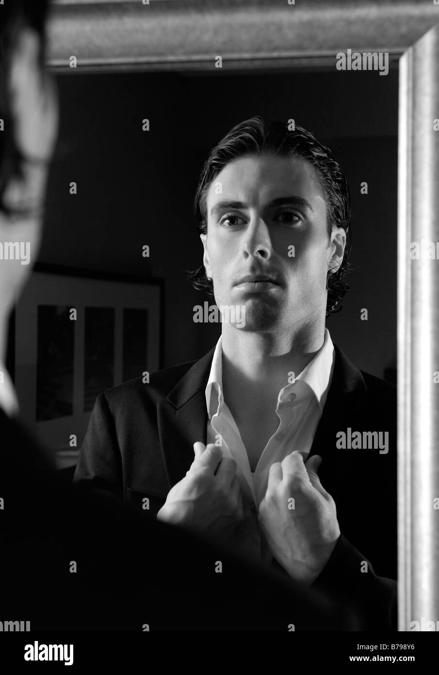 Young man looking at mirror Stock Photo - Alamy