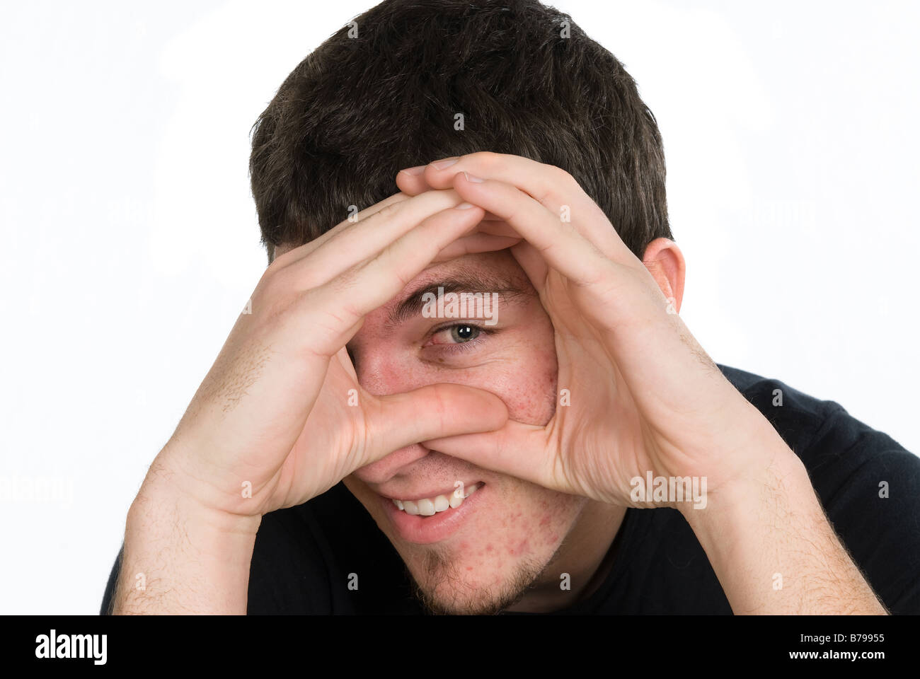 A man peering through his hands isolated on white Stock Photo - Alamy
