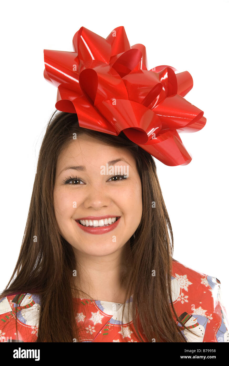 A young Asian woman smiles as she is wrapped in Christmas wrapping ...