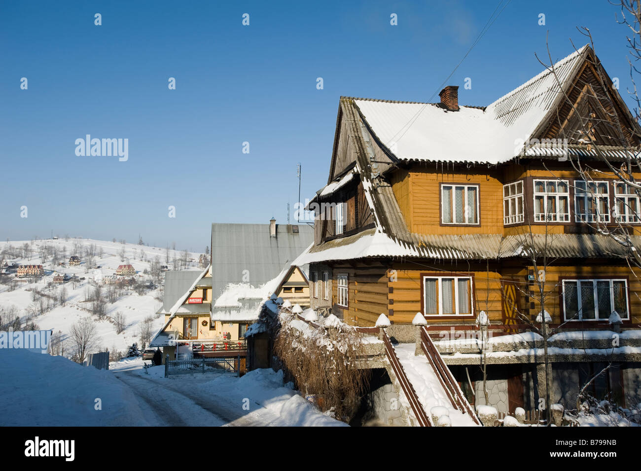 Snow covered village of Bukowina Tatrzanska and typical wooden ...