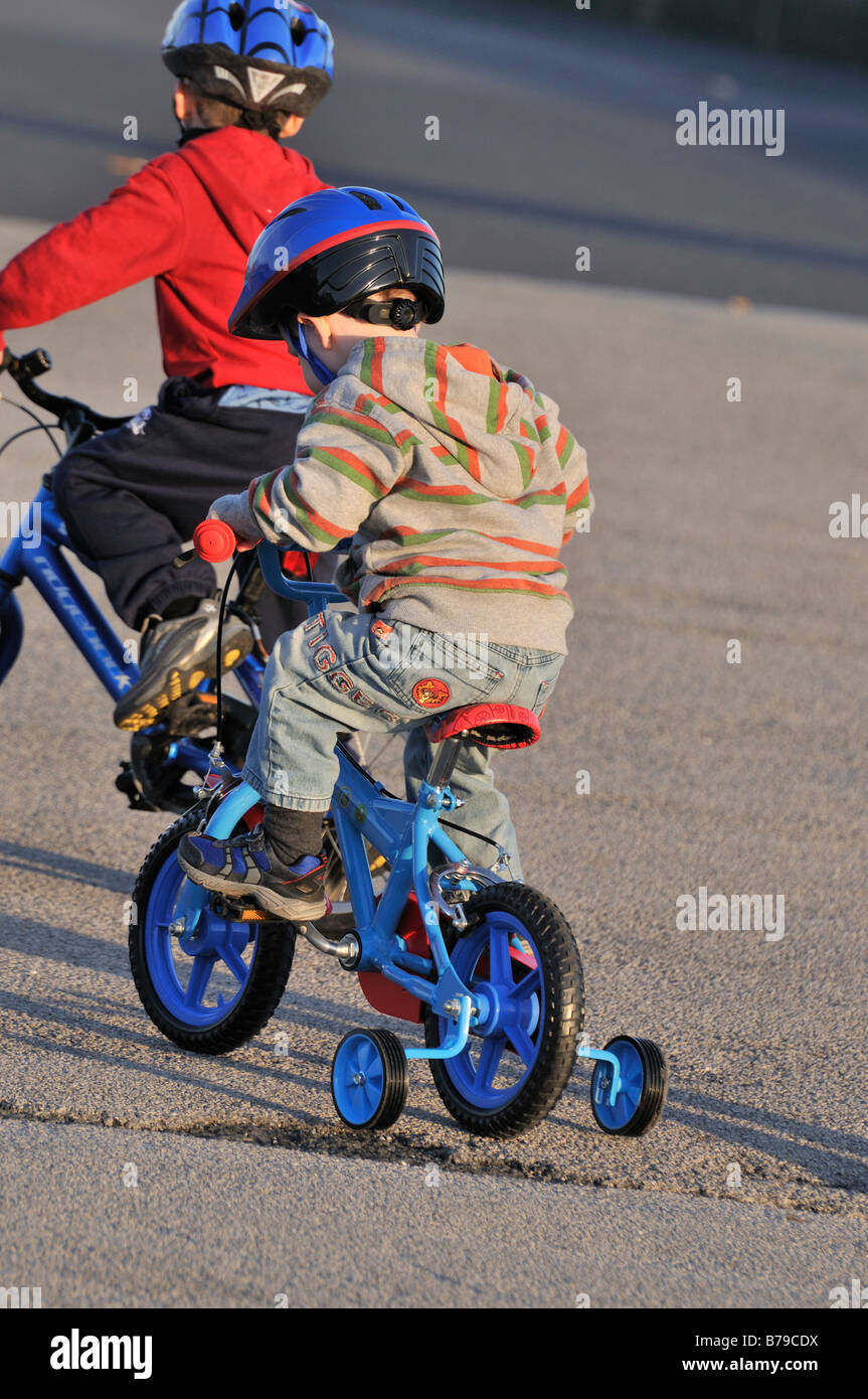 Two brothers boys riding bicycles Stock Photo - Alamy