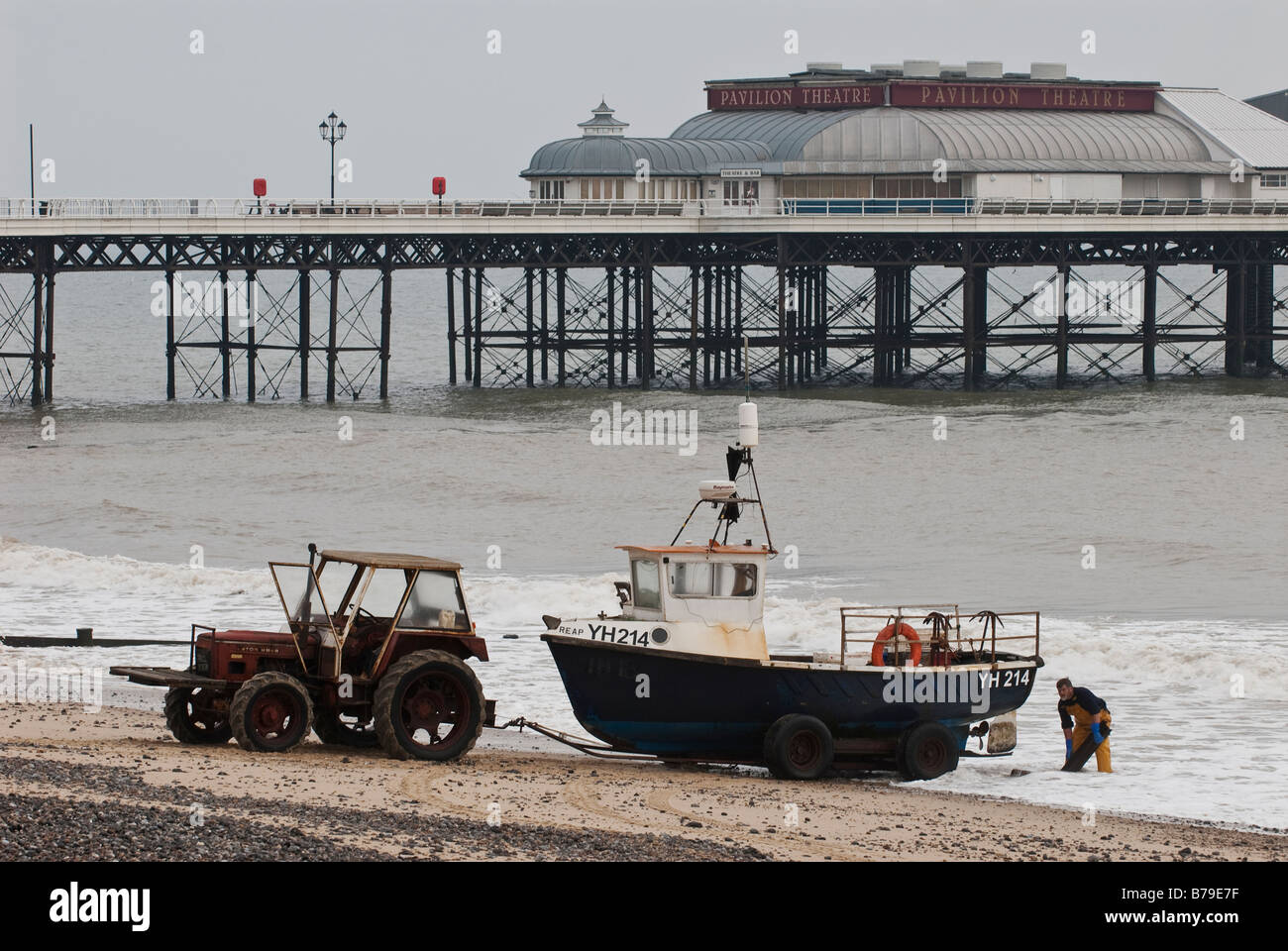 A crab fisherman retrieving his boat with a tractor from the sea near ...