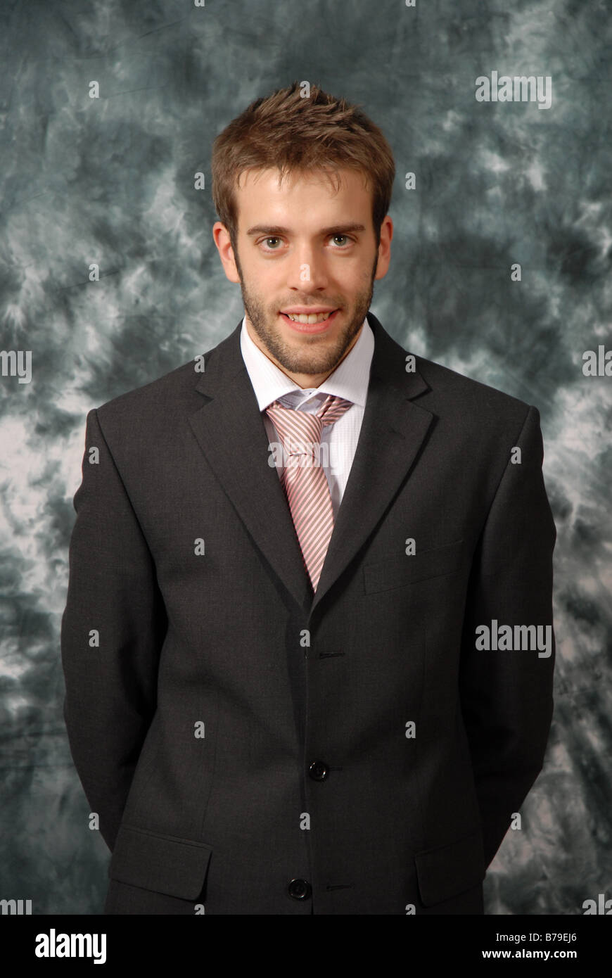 Portrait of a smart young man against a grey backdrop Stock Photo - Alamy
