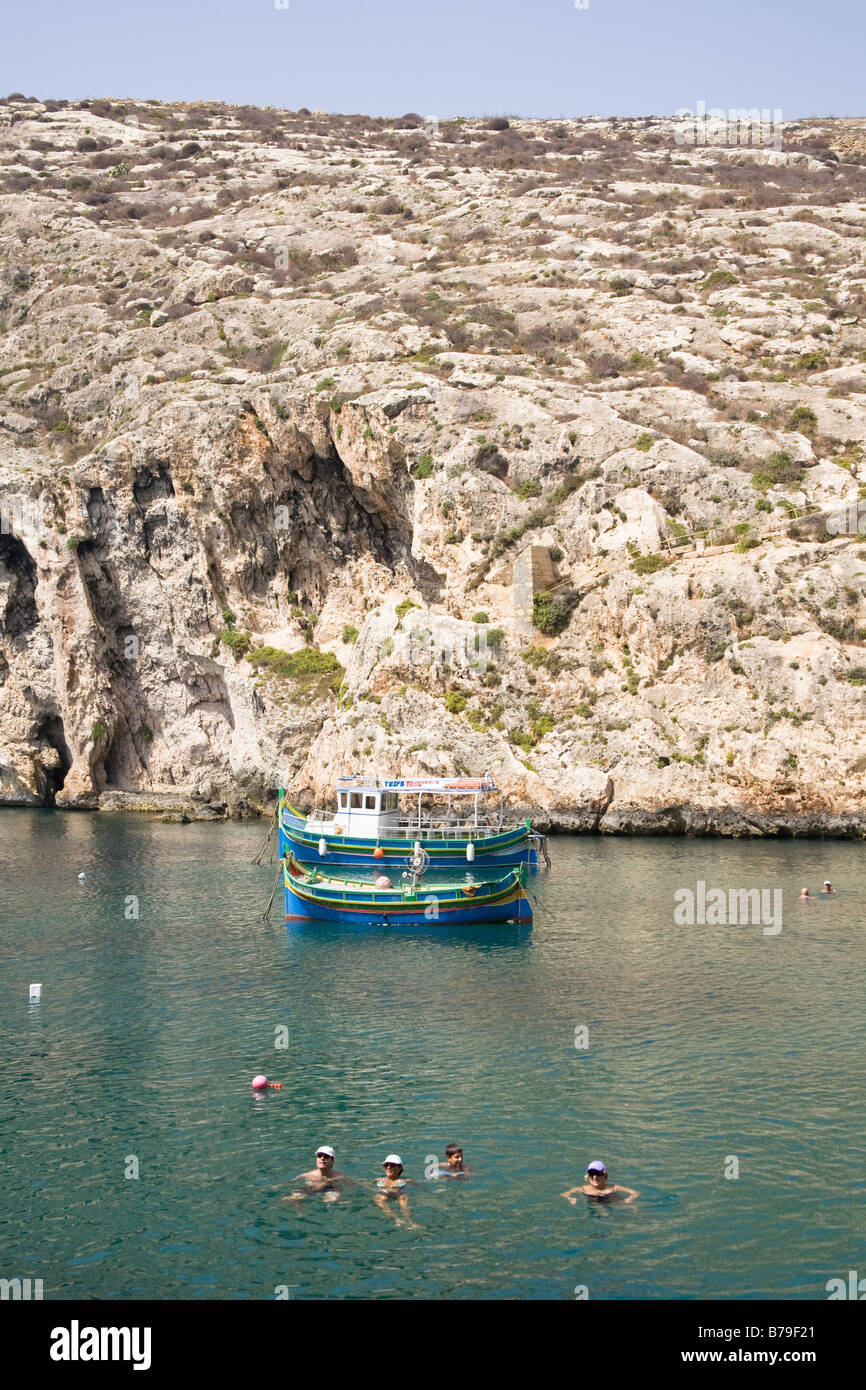 Luzzu fishing boats and people swimming in the Mediterranean Sea ...