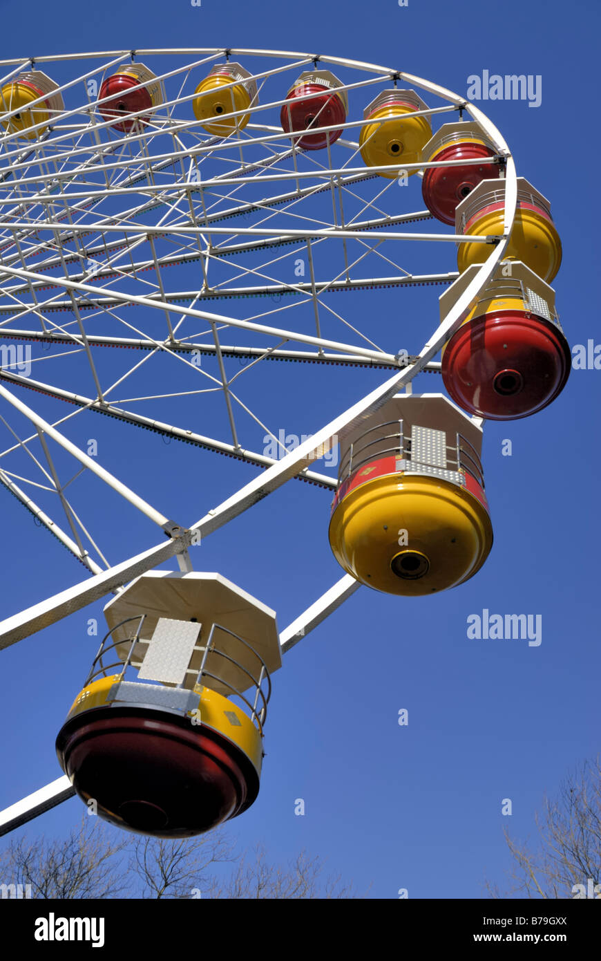 Partial or cropped view of empty red and yellow ferris wheel contrasted ...
