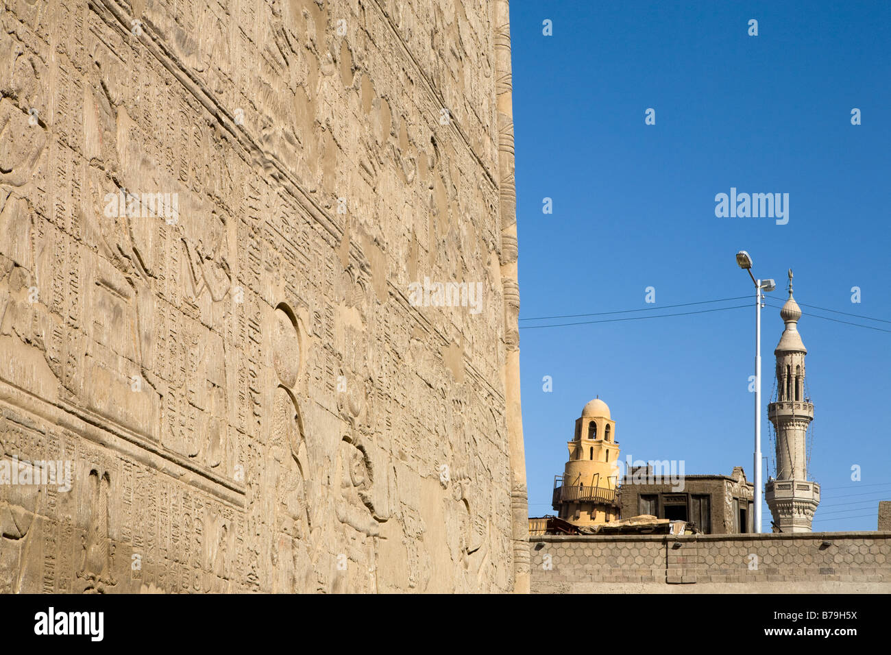 Outside view of the walls of the Temple Of Khnum and the modern town at ...