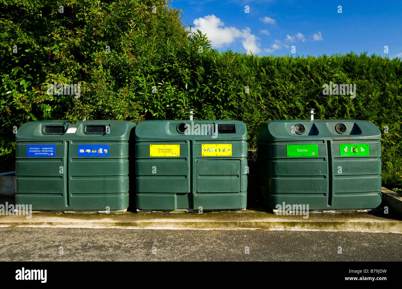 Recycling bins for glass and plastic bottles with hedge behind Stock ...