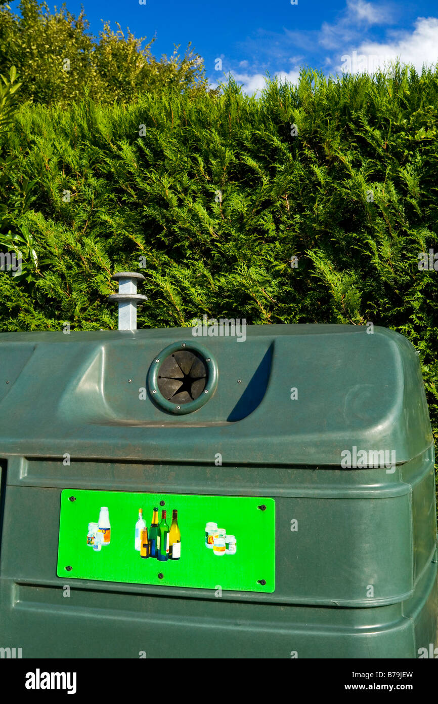 Recycling bin for glass and plastic bottles with hedge behind Stock ...
