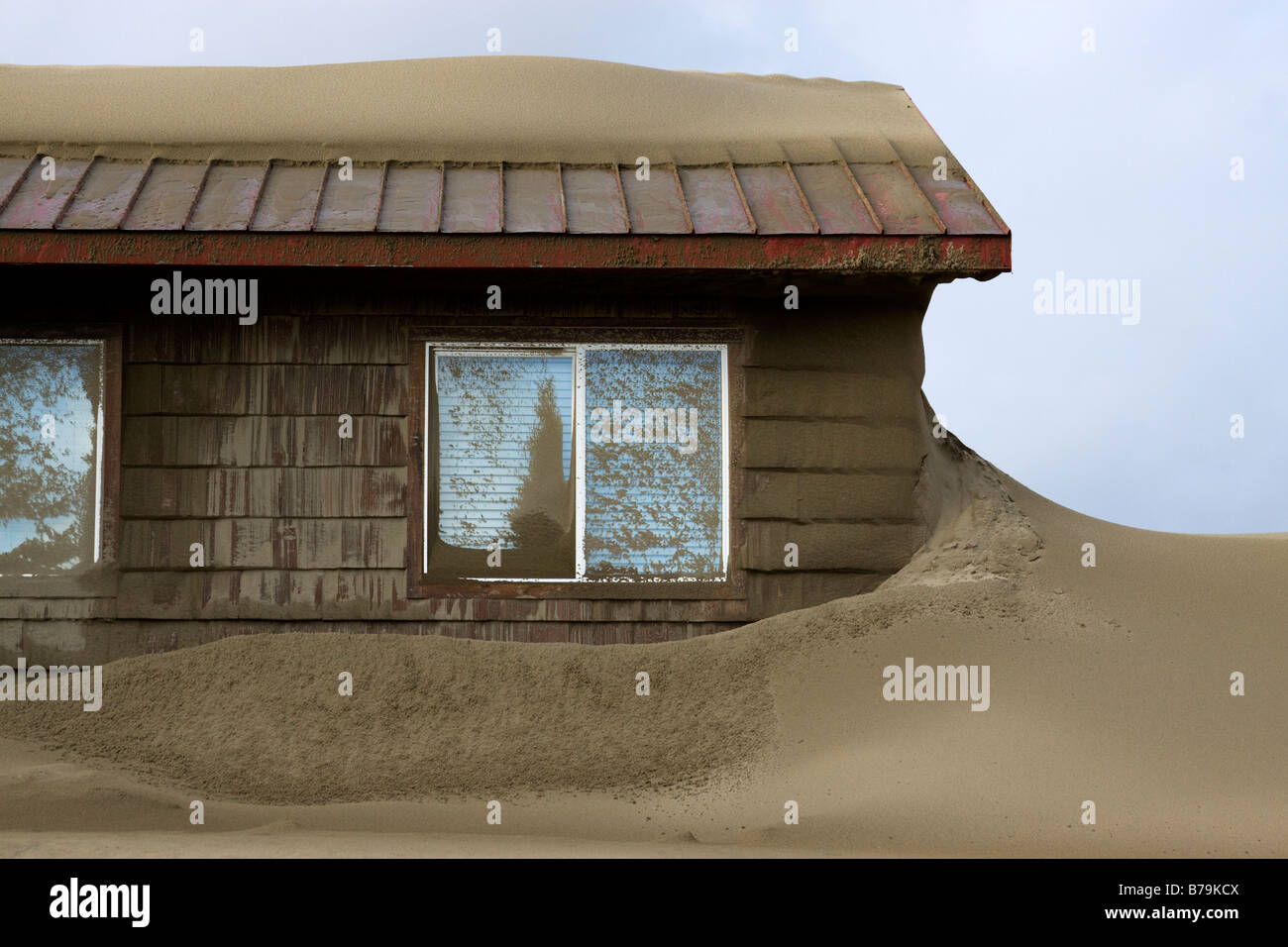 Sand practically buries a house after a large storm on the Oregon coast ...