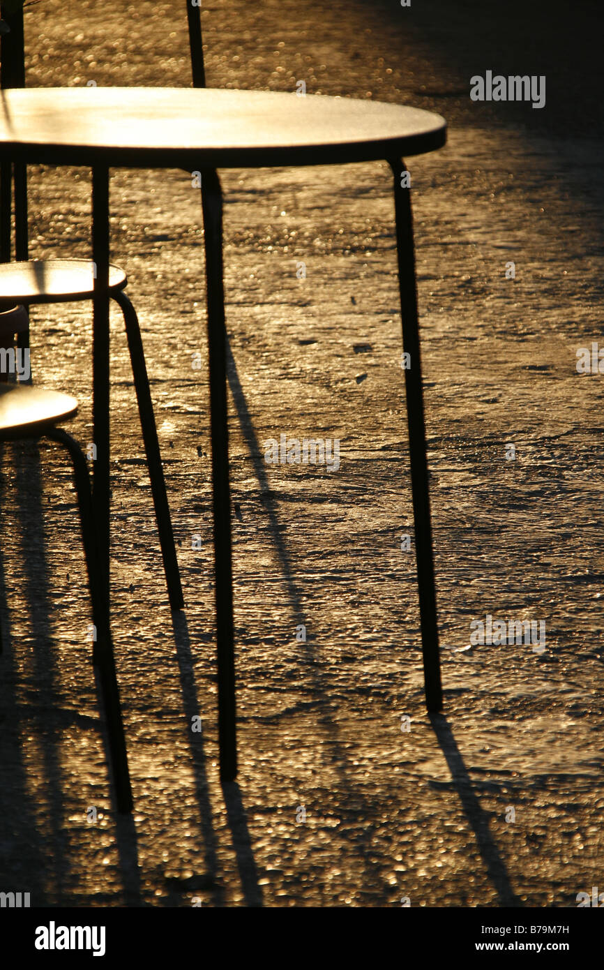 one empty table and chair outside restaurant in street in sun Stock ...