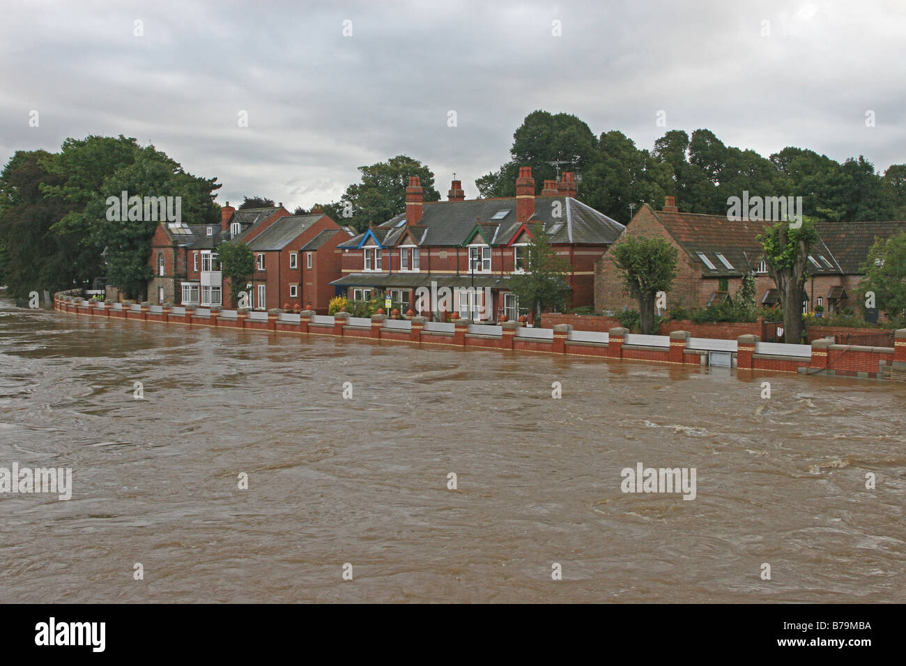 Flood defences protecting houses against a flooded River Wye at ...