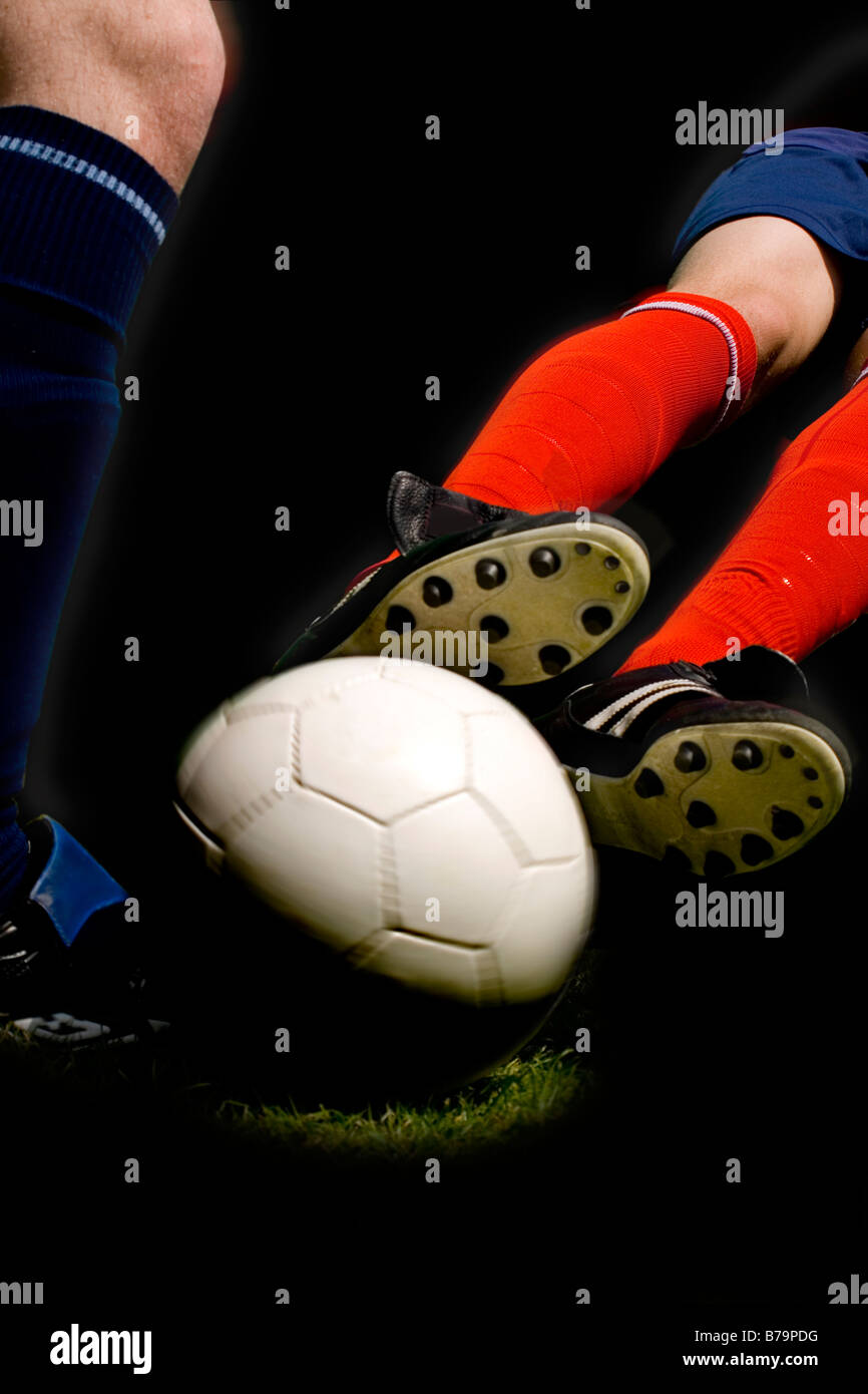 Two footed challenge on a spotlit football. A `red card` challenge ...
