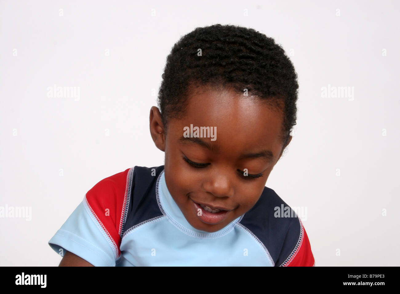 African American boy looking down with a grin Stock Photo - Alamy