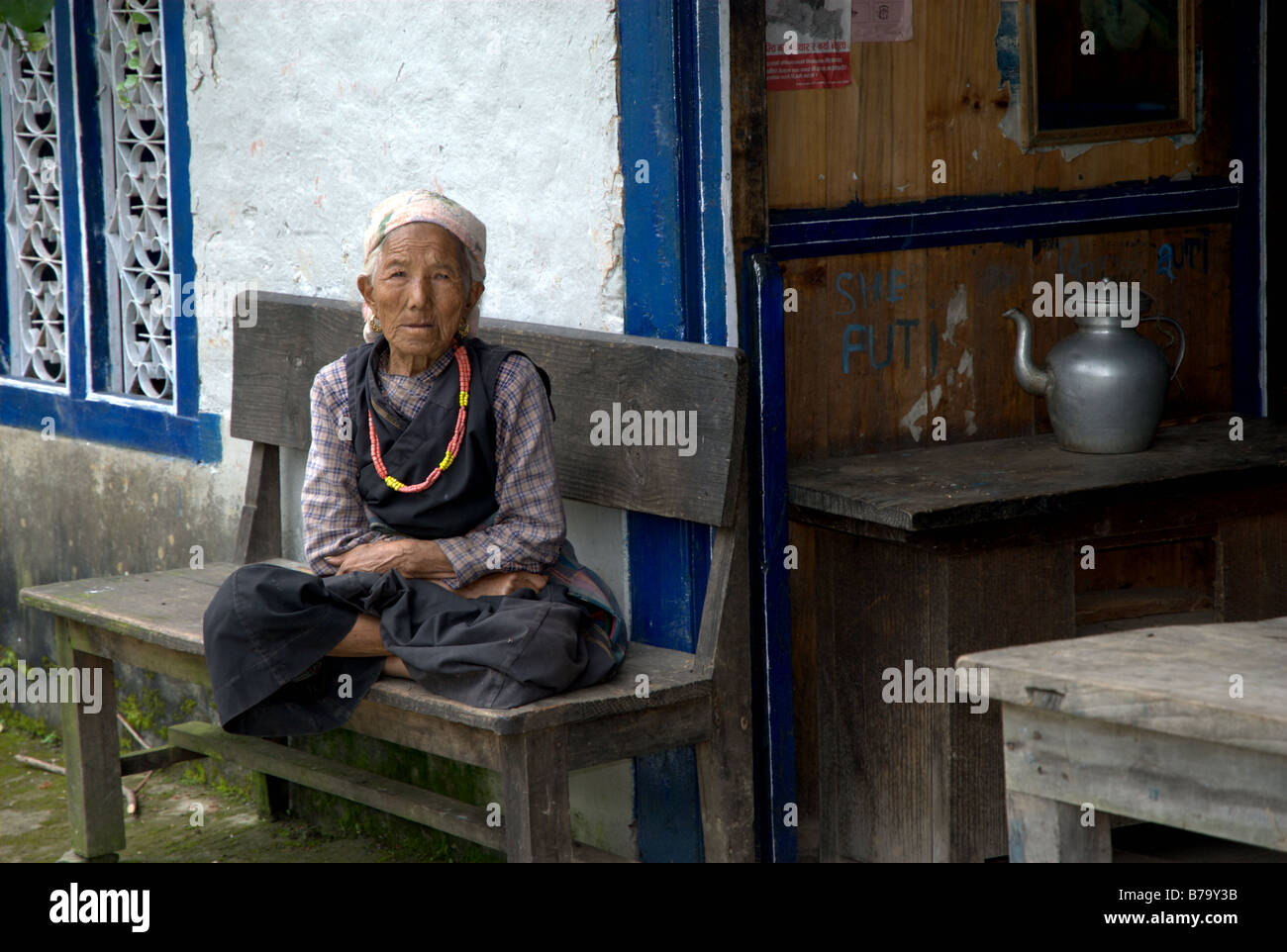 An old woman rests on a bench of her small teahouse, Jiri district ...