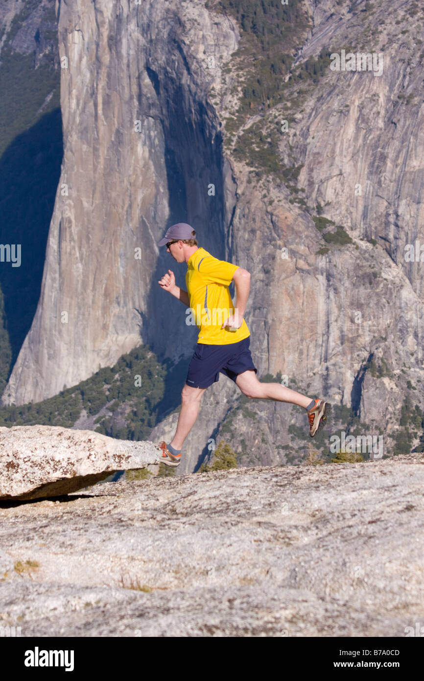 A man running in Yosemite National Park above El Capitan in California ...