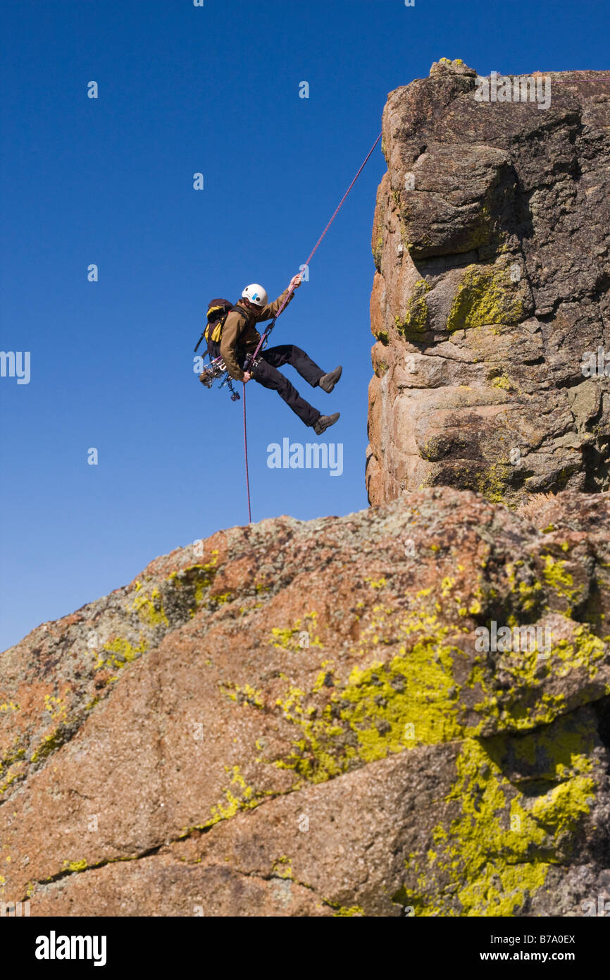 A man rappelling off a cliff Stock Photo - Alamy