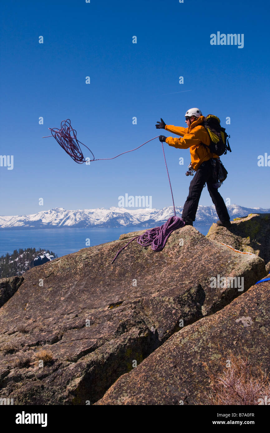 A mountaineer throwing a rope off a cliff above Lake Tahoe and the ...