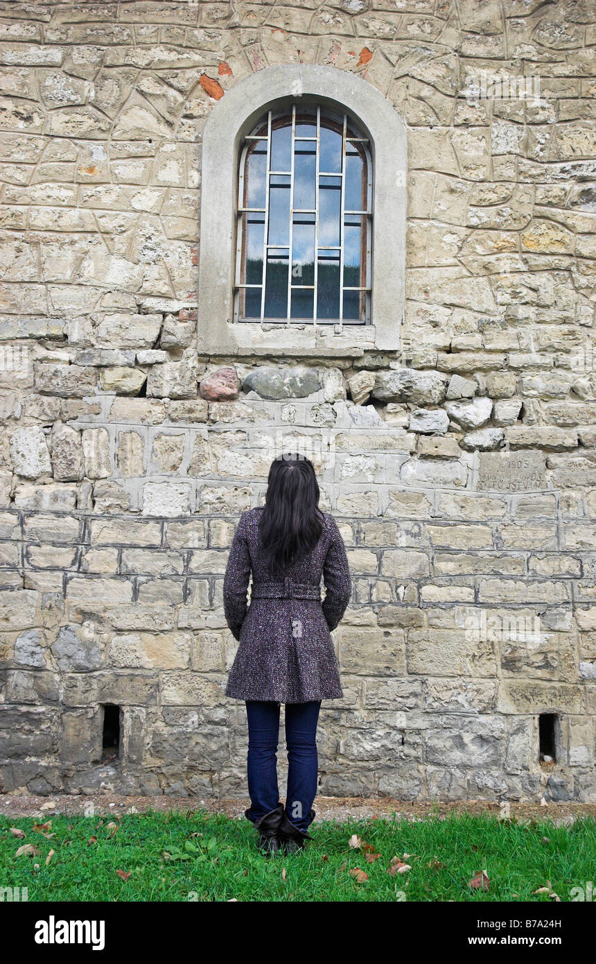 Young woman looking at window Stock Photo - Alamy