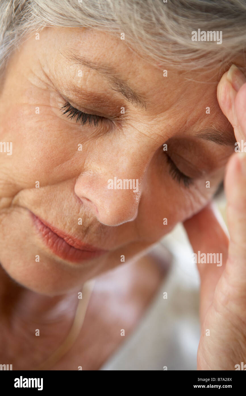 Senior Woman With Head In Hands Looking Weary Stock Photo - Alamy