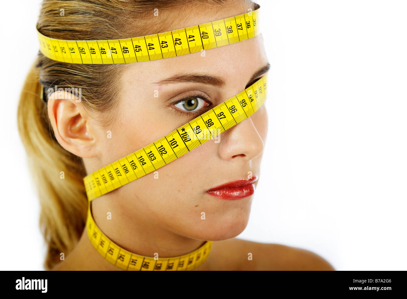 Young woman with measuring tape wrapped around her head and neck Stock ...