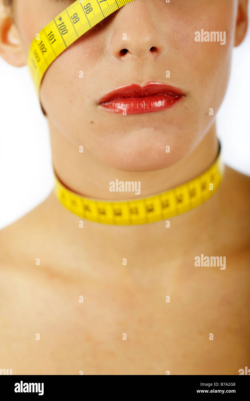 Young woman with measuring tape wrapped around her head and neck Stock ...
