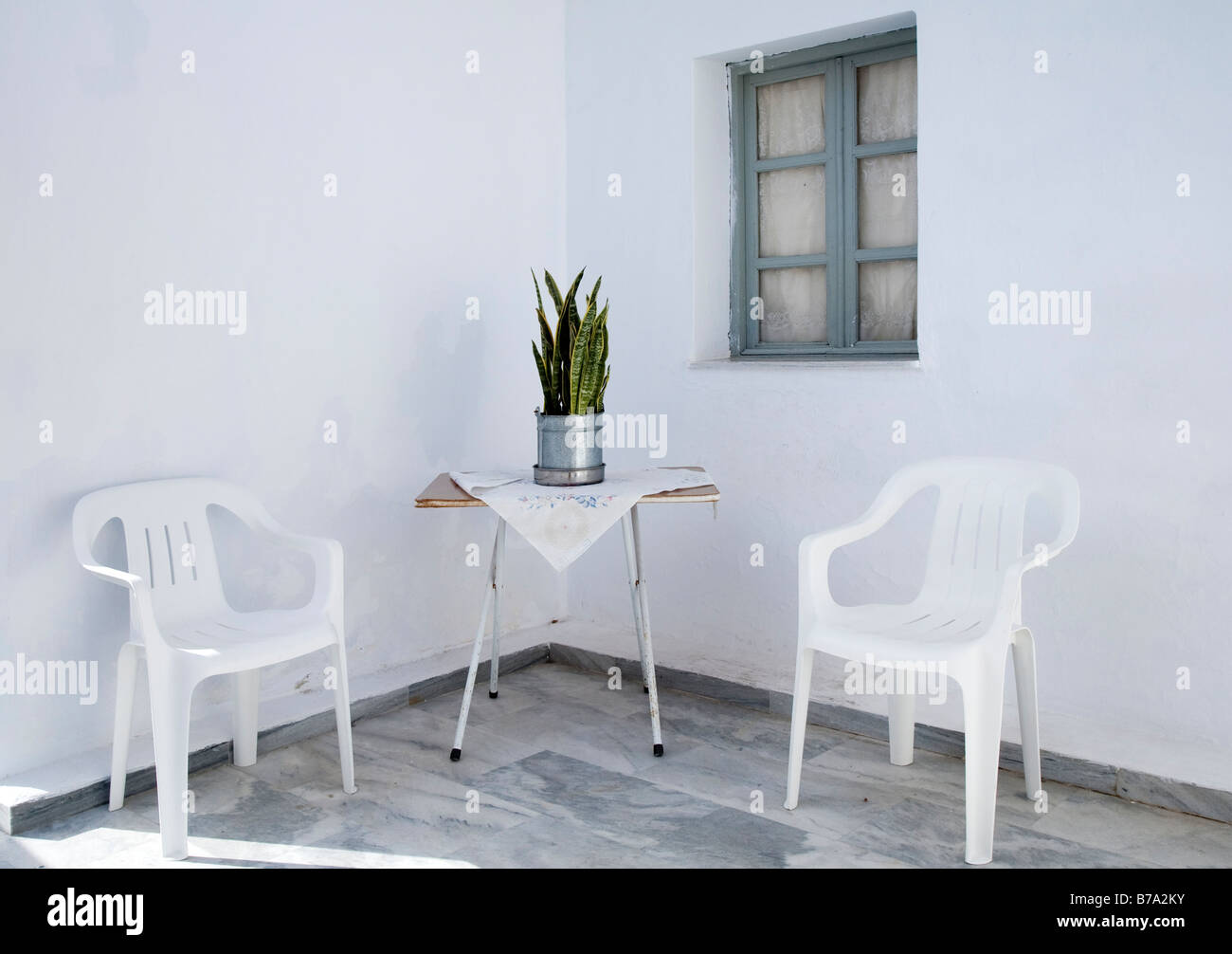 Table chairs window plant Oia Santorini Cyclades Greece Stock Photo - Alamy