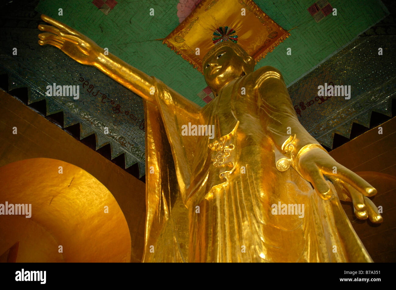 Large standing golden Buddha statue with outstreched arm and pointing ...