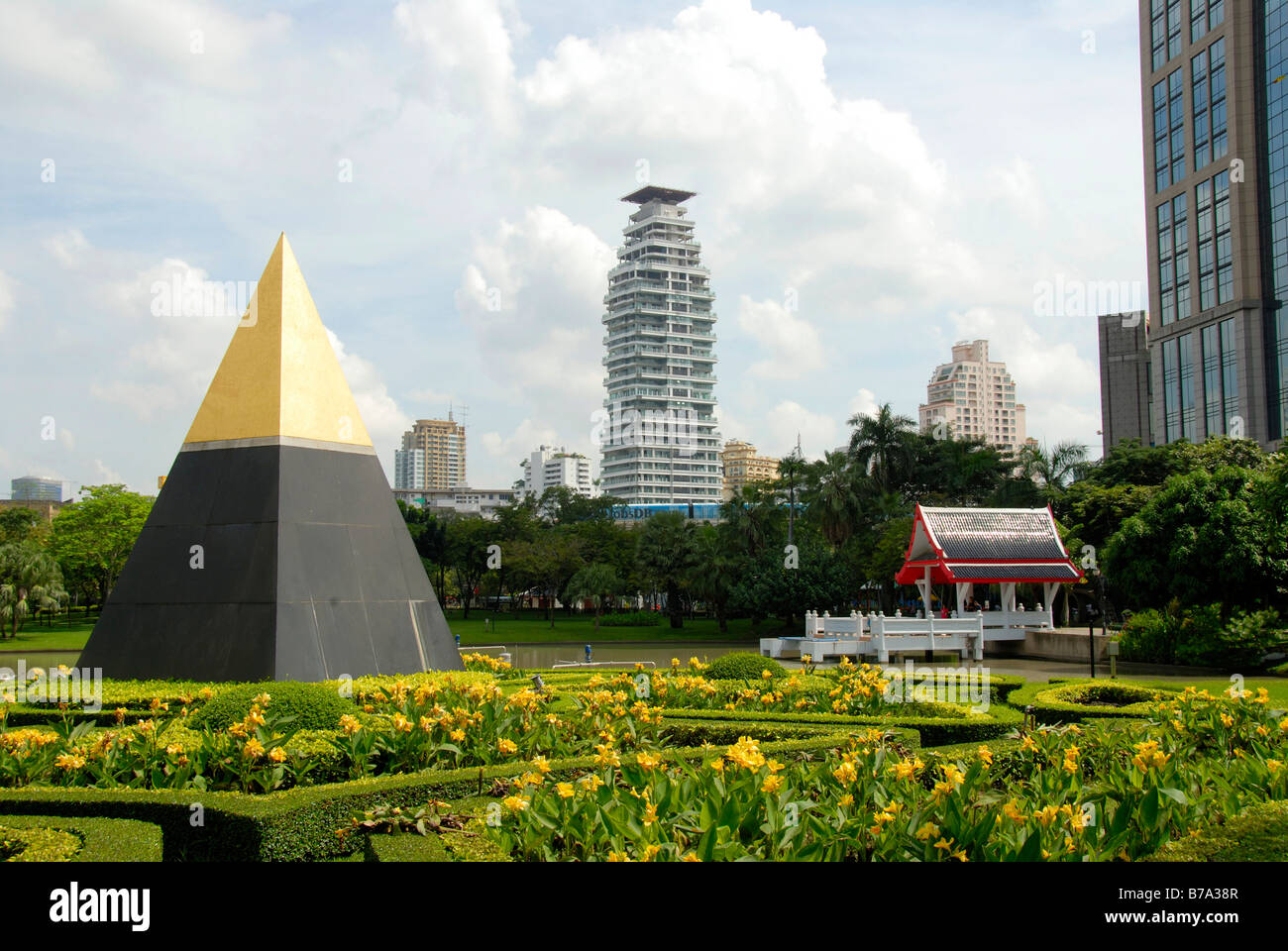 Pyramid with a golden peak in front of a temple and modern multistory ...