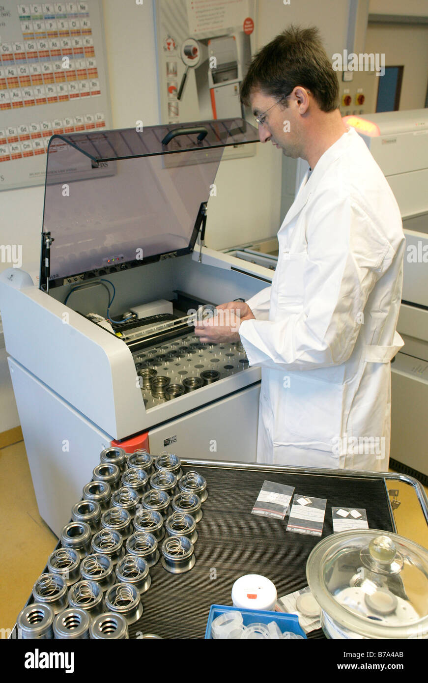 Staff member of the quality control, using an X-Ray fluorescent machine ...