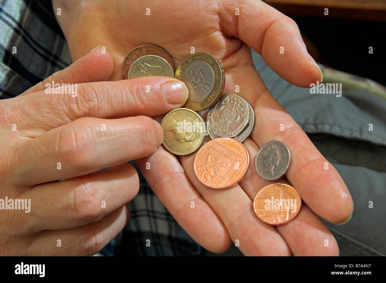 Closeup of middle aged woman counting out change in her hand British ...
