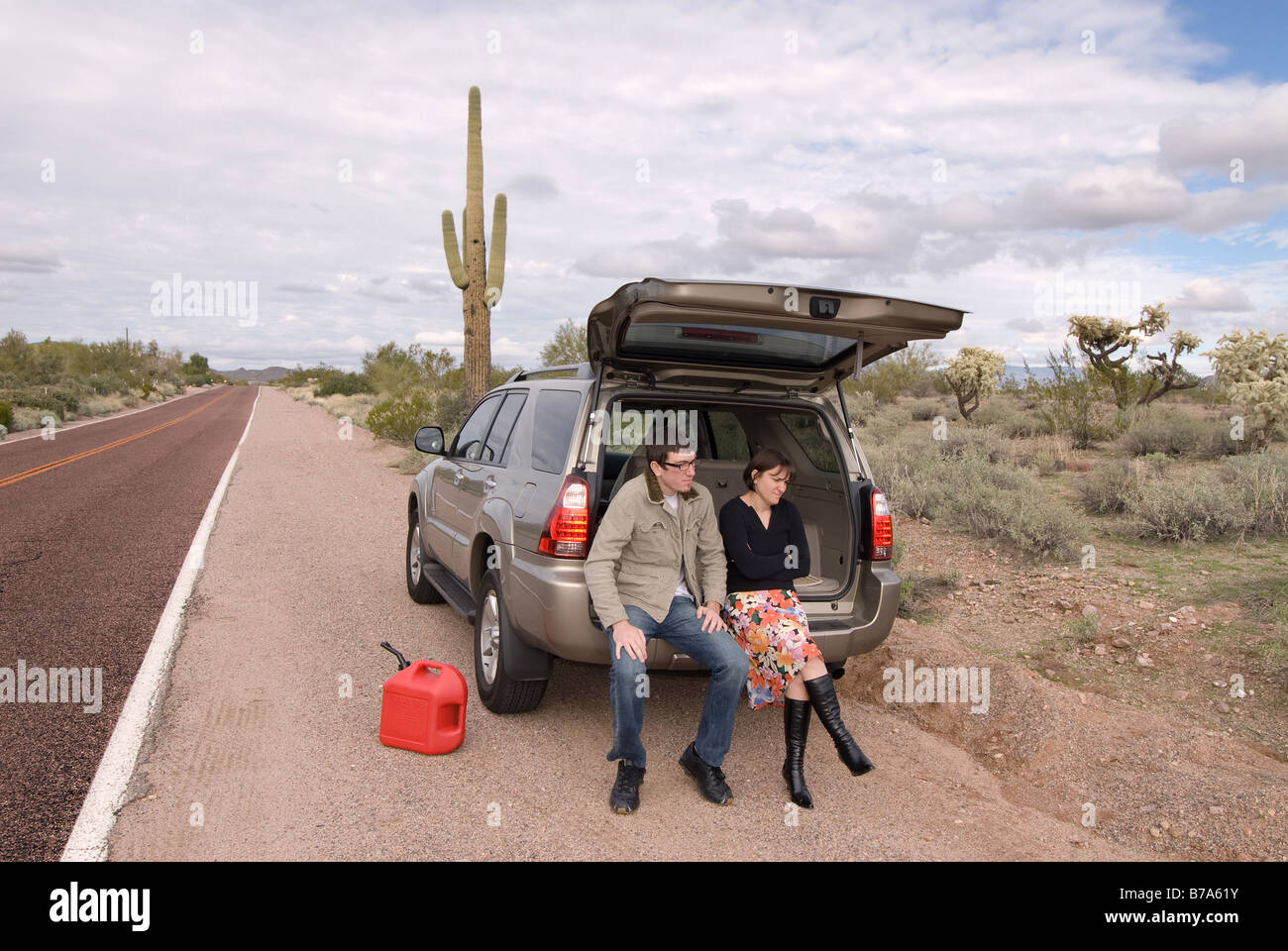 Two people are stranded on the side of a remote desert road out of gas ...