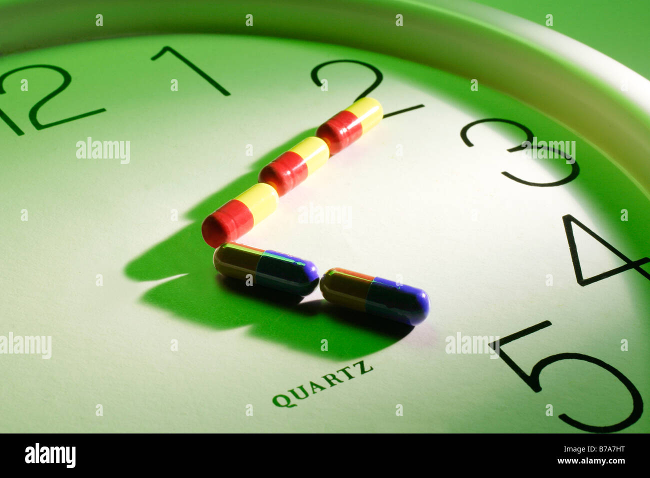 Capsules on clock face, close-up Stock Photo - Alamy