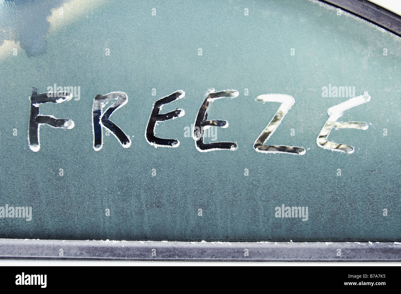 The word 'Freeze' written by a finger on a frosty and iced window of a ...